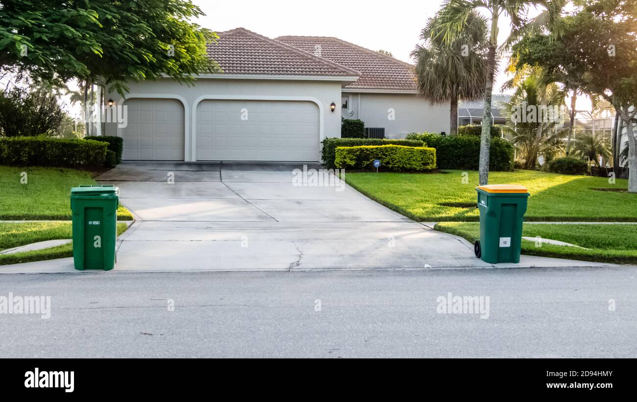 Green and yellow waste management garbage cans at the curb for trash ...