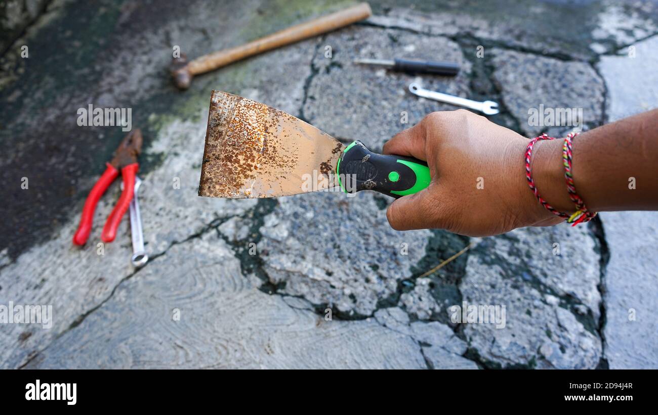 Close up hand holding artisan tools Stock Photo - Alamy