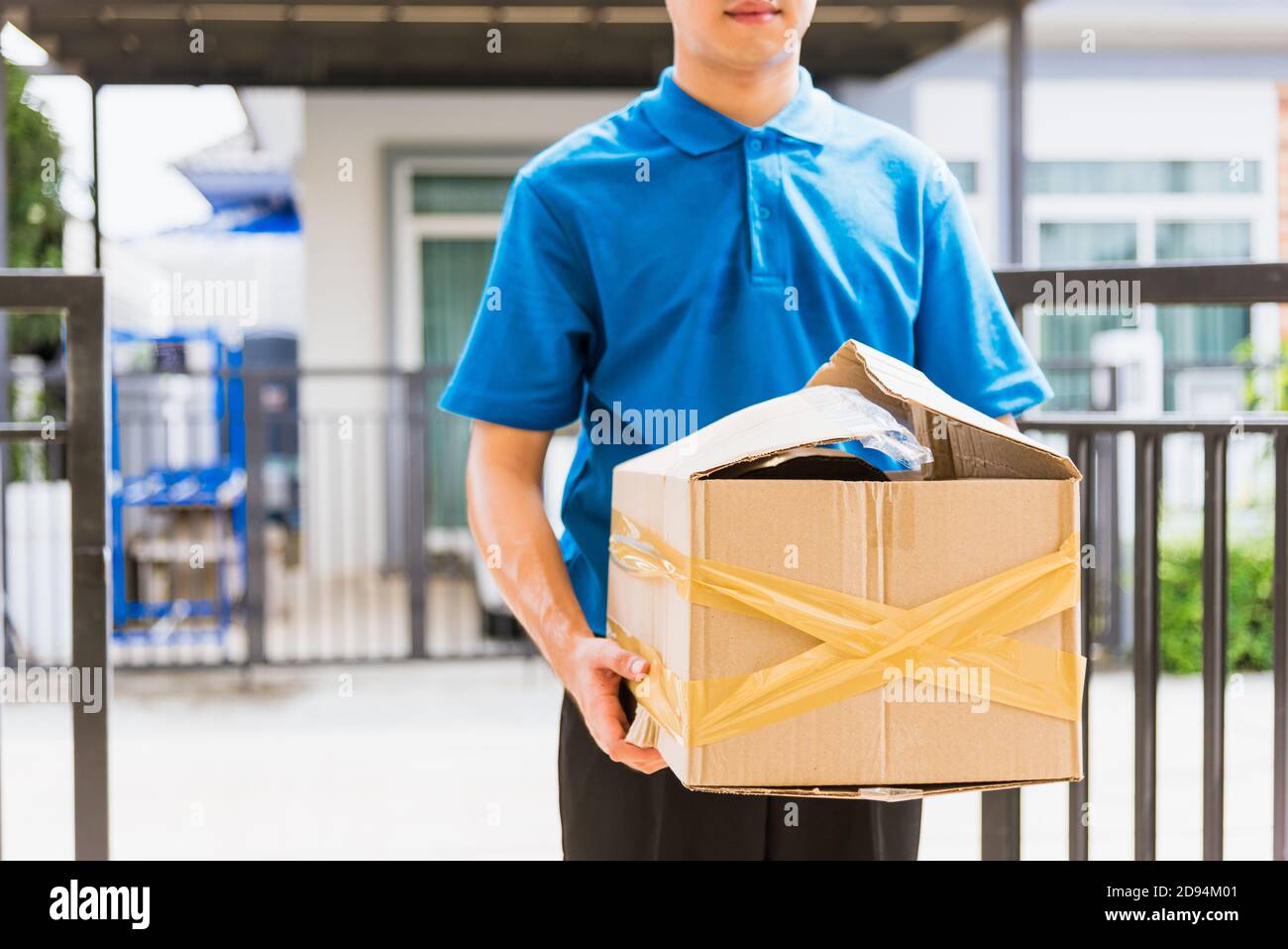 Asian young delivery man in blue uniform he emotional falling courier ...