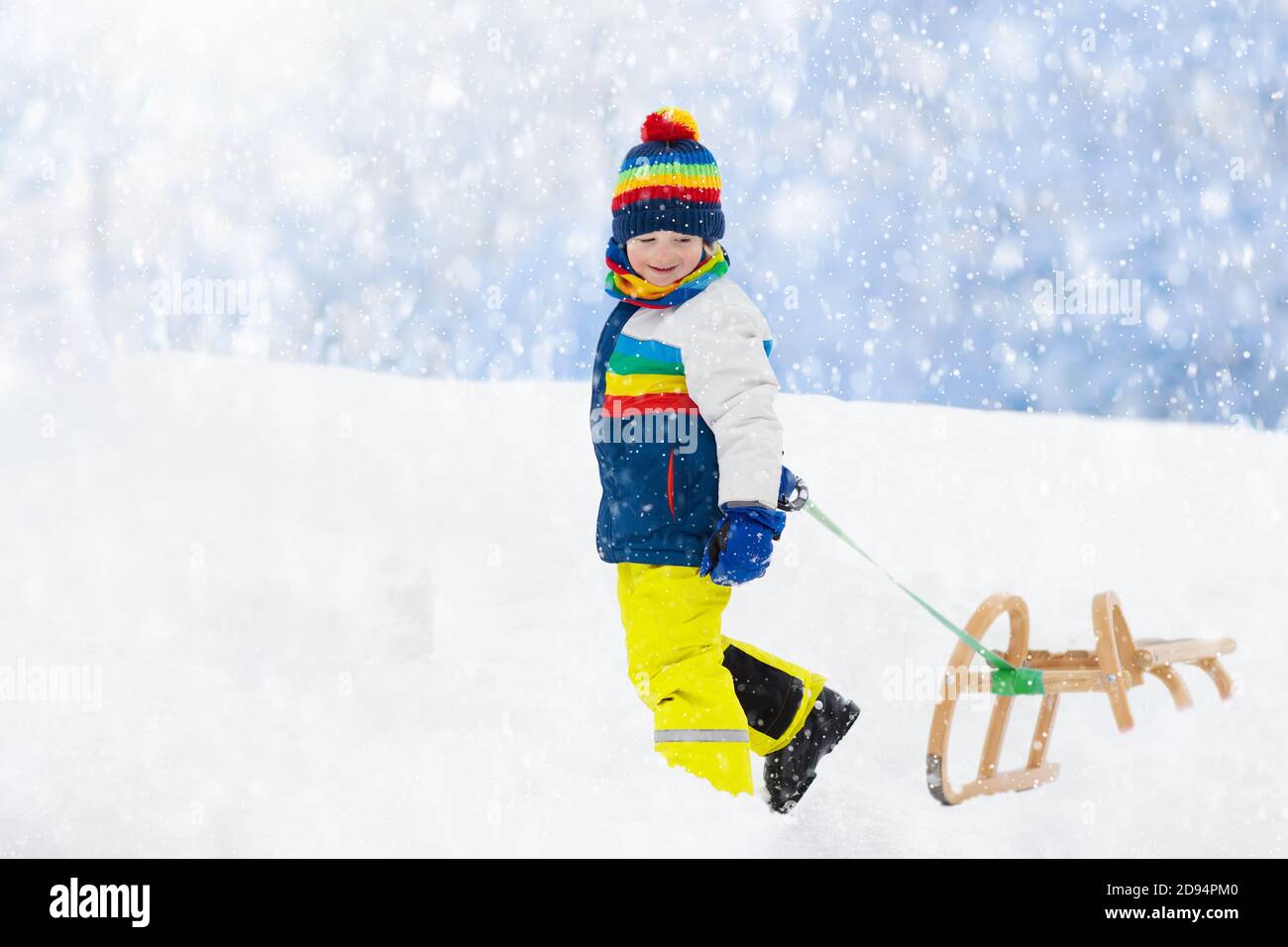 Little boy enjoying a sleigh ride. Child sledding. Toddler kid riding a ...