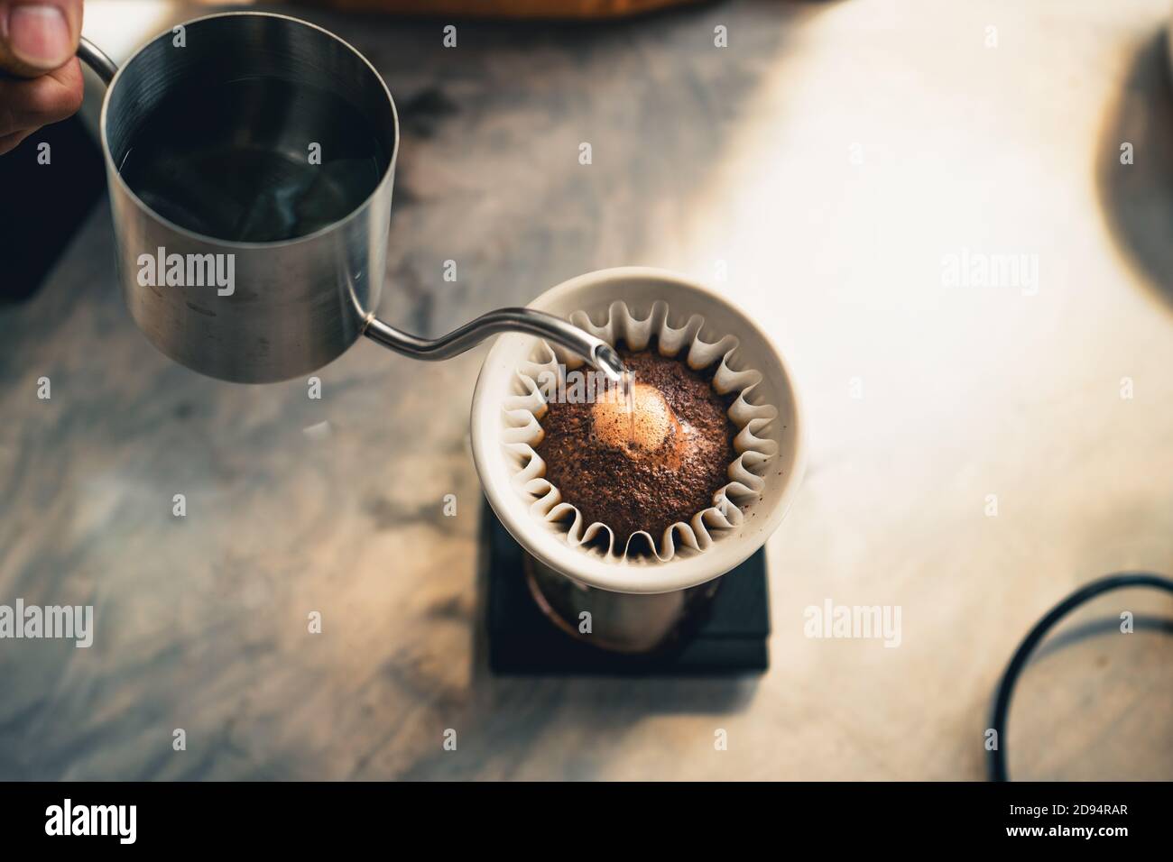 Drip coffee, barista pouring water on coffee ground with filter at home ...