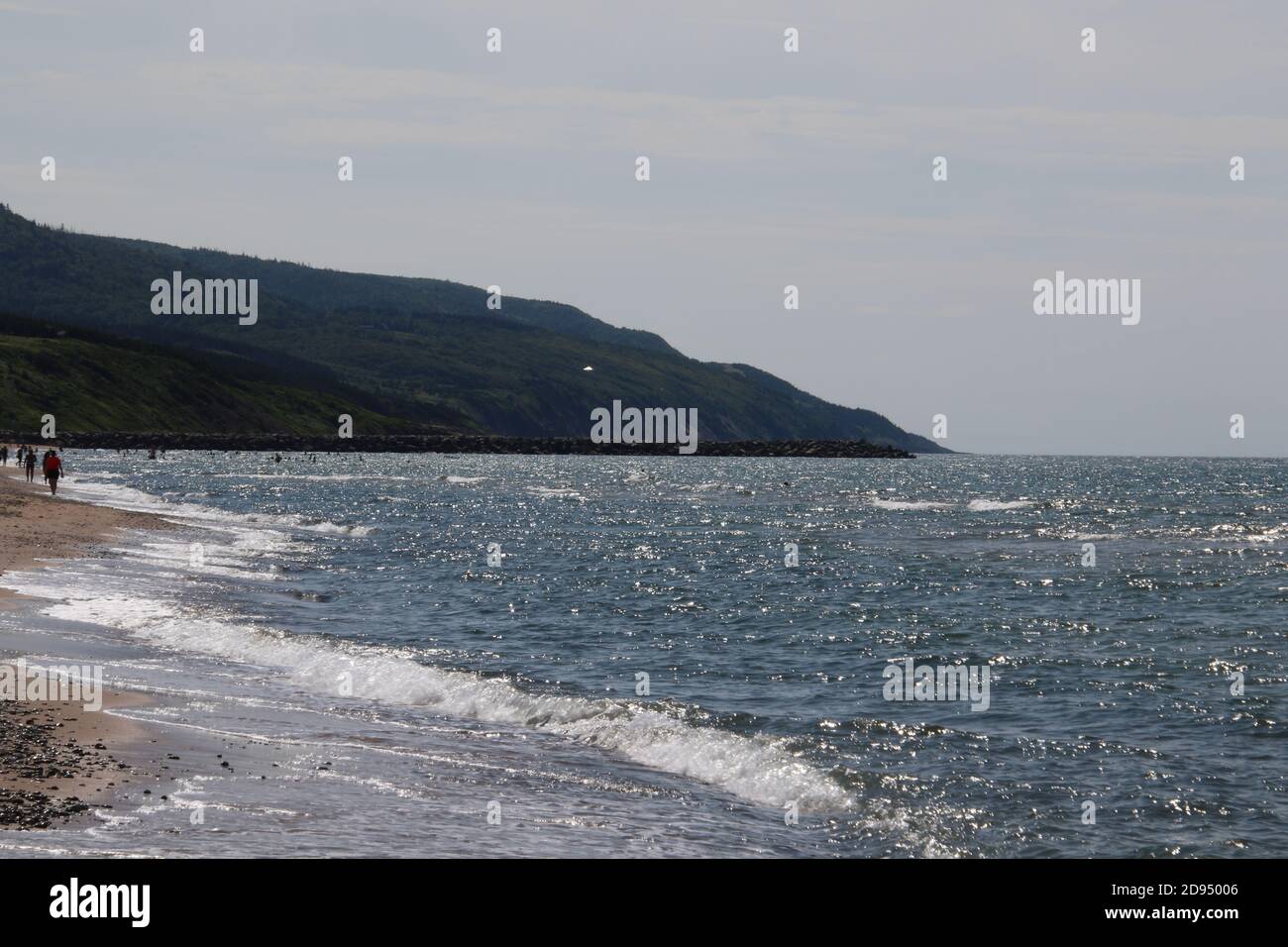 A view of the Atlantic ocean on a sunny day with the land sloping into ...