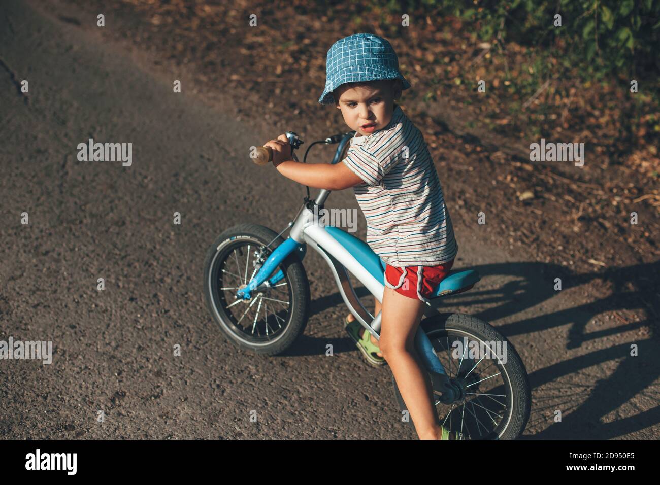 Upper view photo of a caucasian boy looking back while riding a bike on ...
