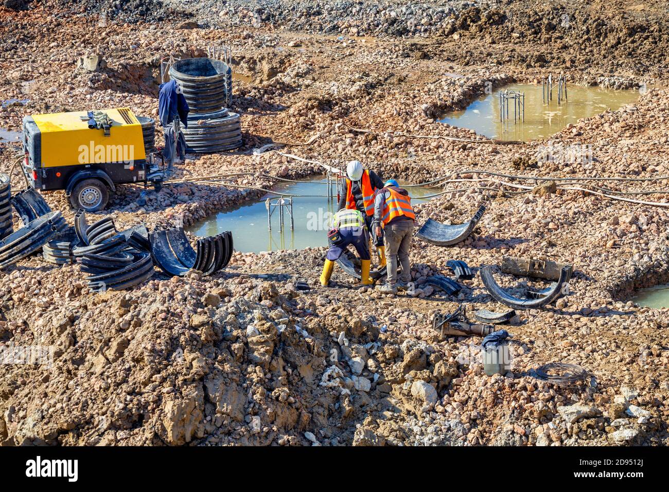 Team of construction workers working on building site. Teamwork in ...