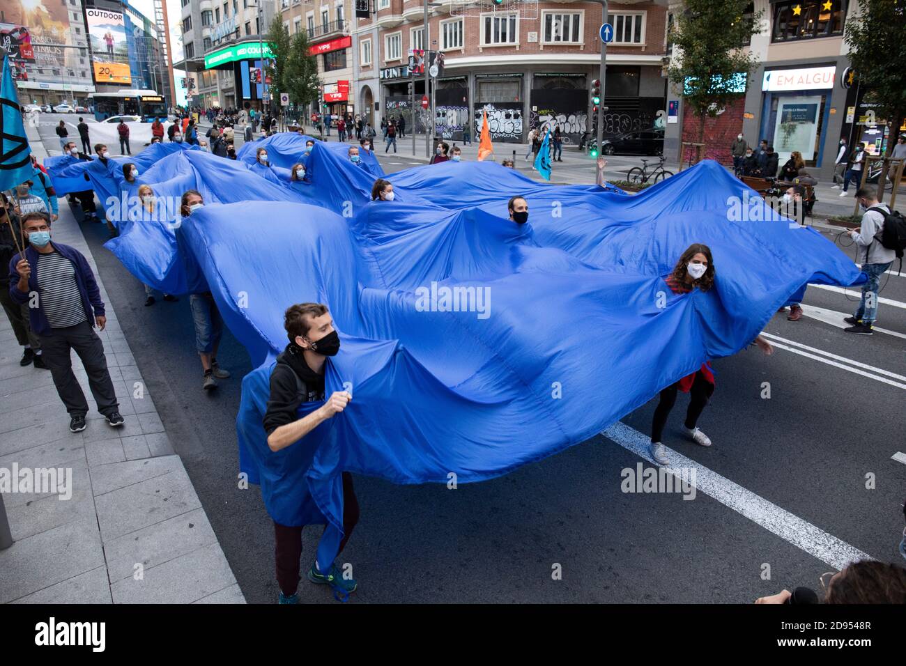 Activists are seen inside the blue cloth while marching on the street ...