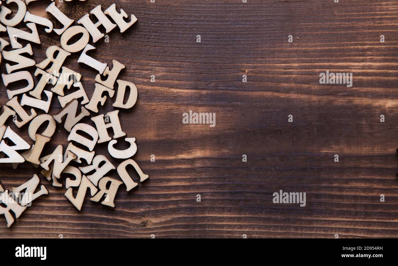 Letters of the English alphabet on a dark wooden background. The ...