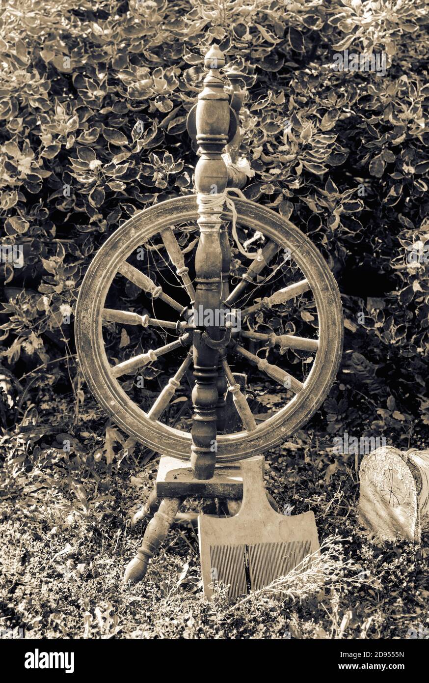 Pretty old wooden spinning wheel at day in sepia Stock Photo - Alamy