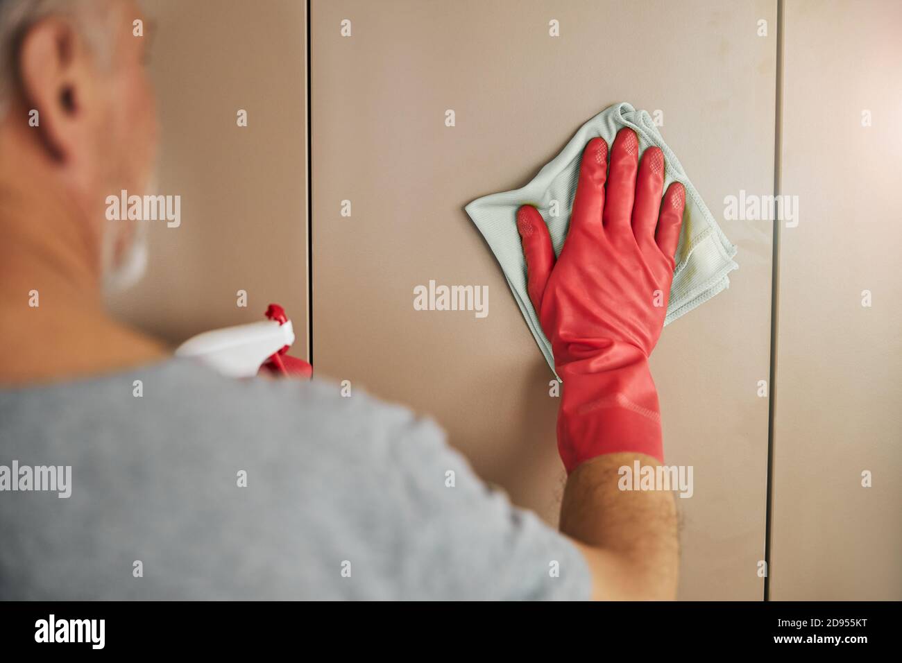 Neat aged gentleman wiping walls of his house clean Stock Photo - Alamy
