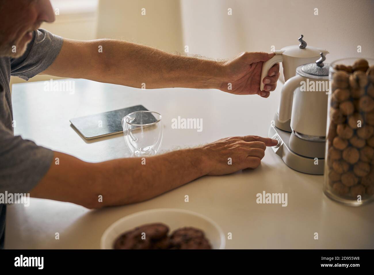 Aged man turning on his kettle to make some tea Stock Photo - Alamy