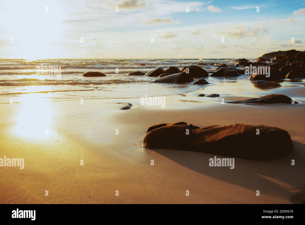 Rock on beach with the sunset at sky Stock Photo - Alamy