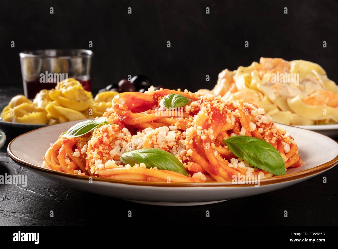 Pasta with tomato sauce, basil and Parmesan, a close-up in a restaurant ...