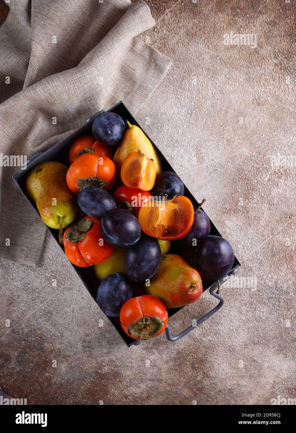 mix autumn fruits persimmon plum and pear Stock Photo - Alamy