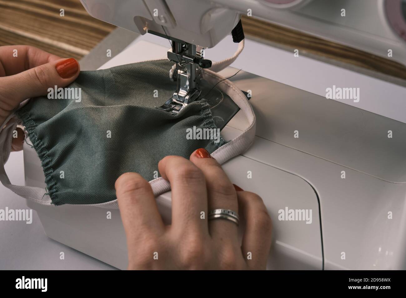 Woman sewing cloth cotton face mask to protect from corona virus ...