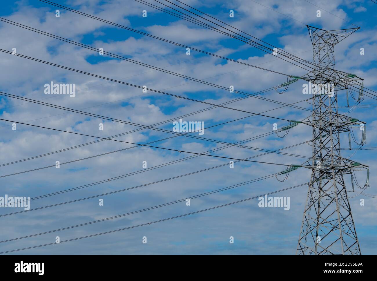 High voltage electric pylon and electrical wire against blue sky and ...
