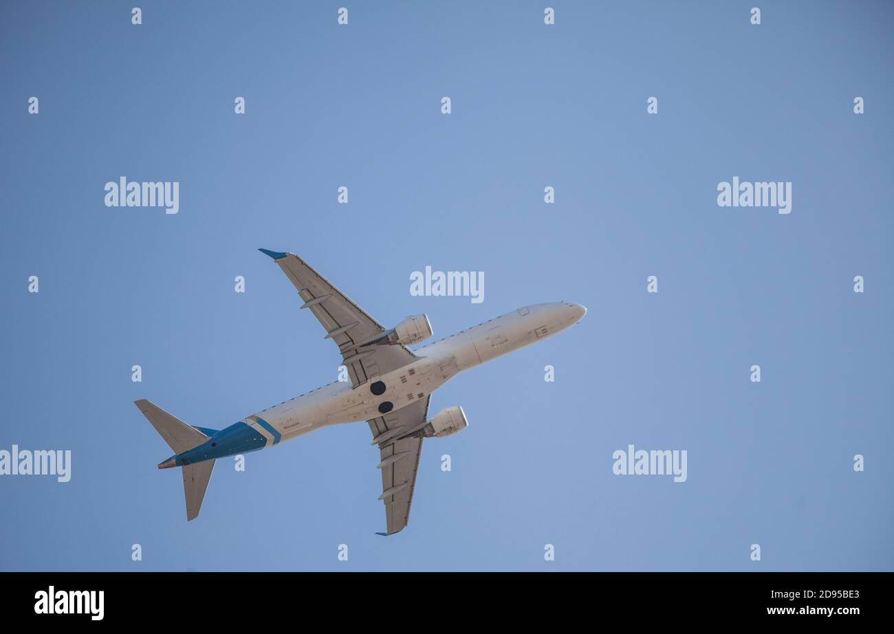 White plane flies in the sky. Bottom view. Takeoff and landing. Arrival ...
