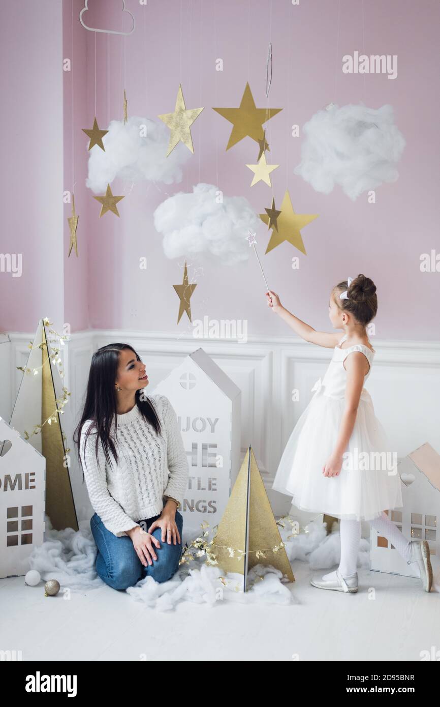 Beautiful mom with daughter fairy pressed against each other on magic ...