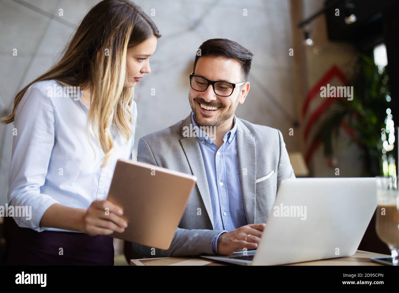 Cheerful coworkers in office working and brainstorming together Stock ...