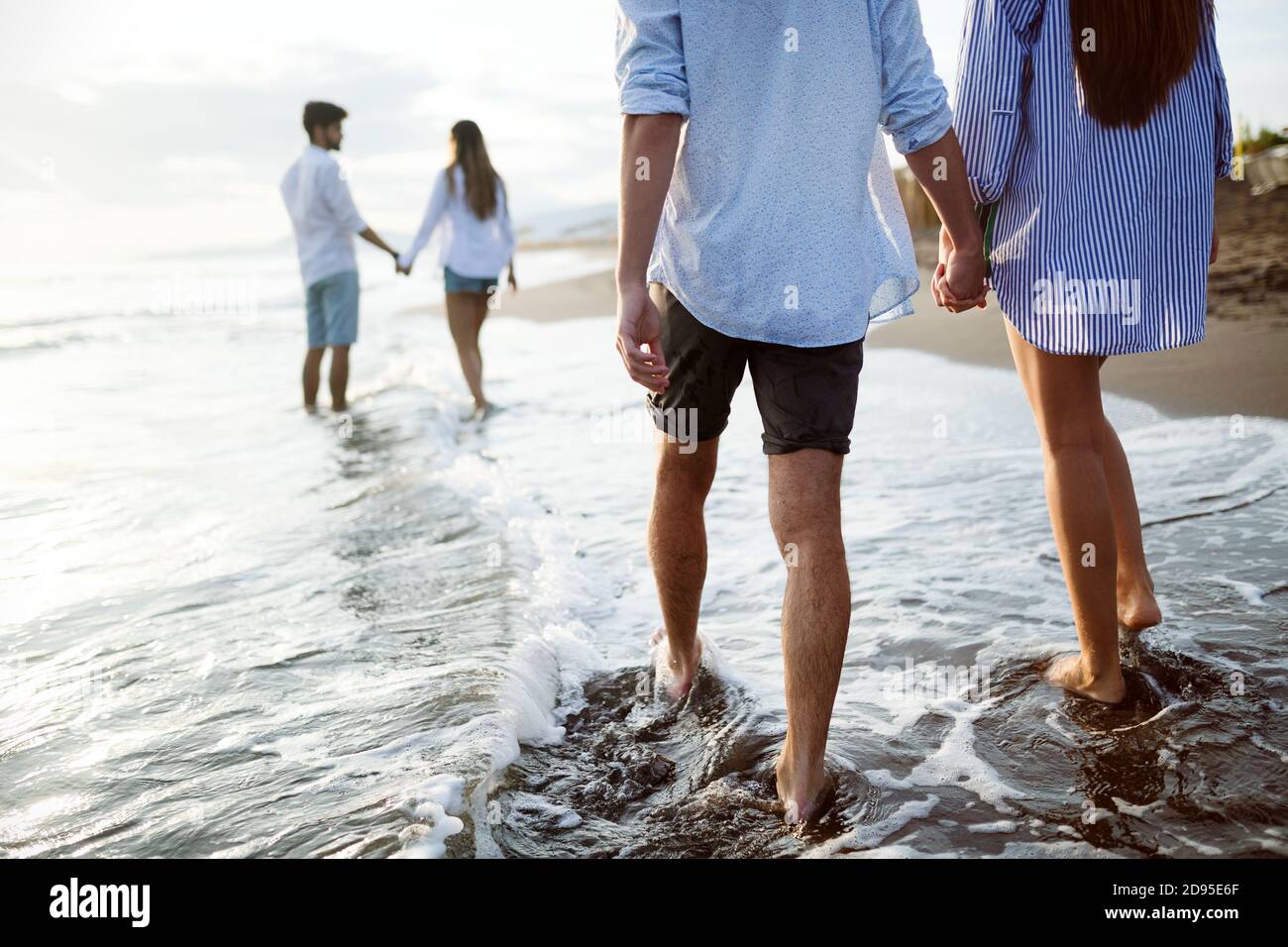 Friends having fun on the beach under sunset sunlight Stock Photo - Alamy