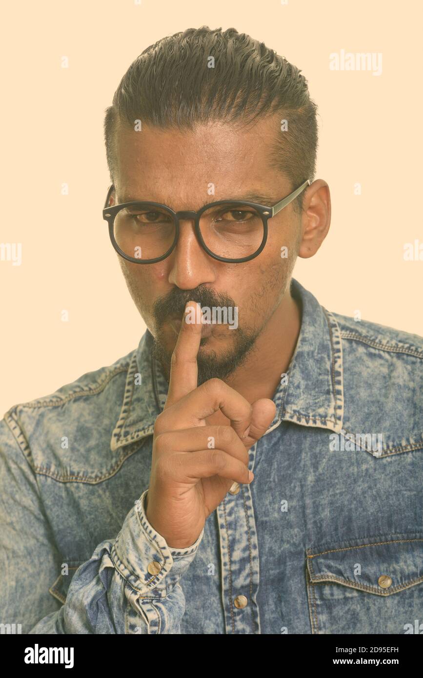 Young Indian man with finger on lips Stock Photo - Alamy