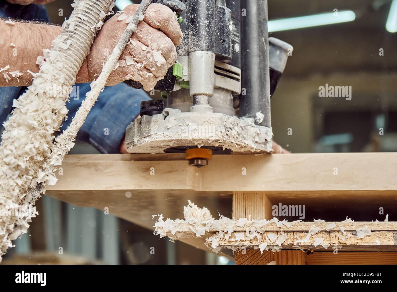Carpenter with hand electric router machine at work. Milling process of ...