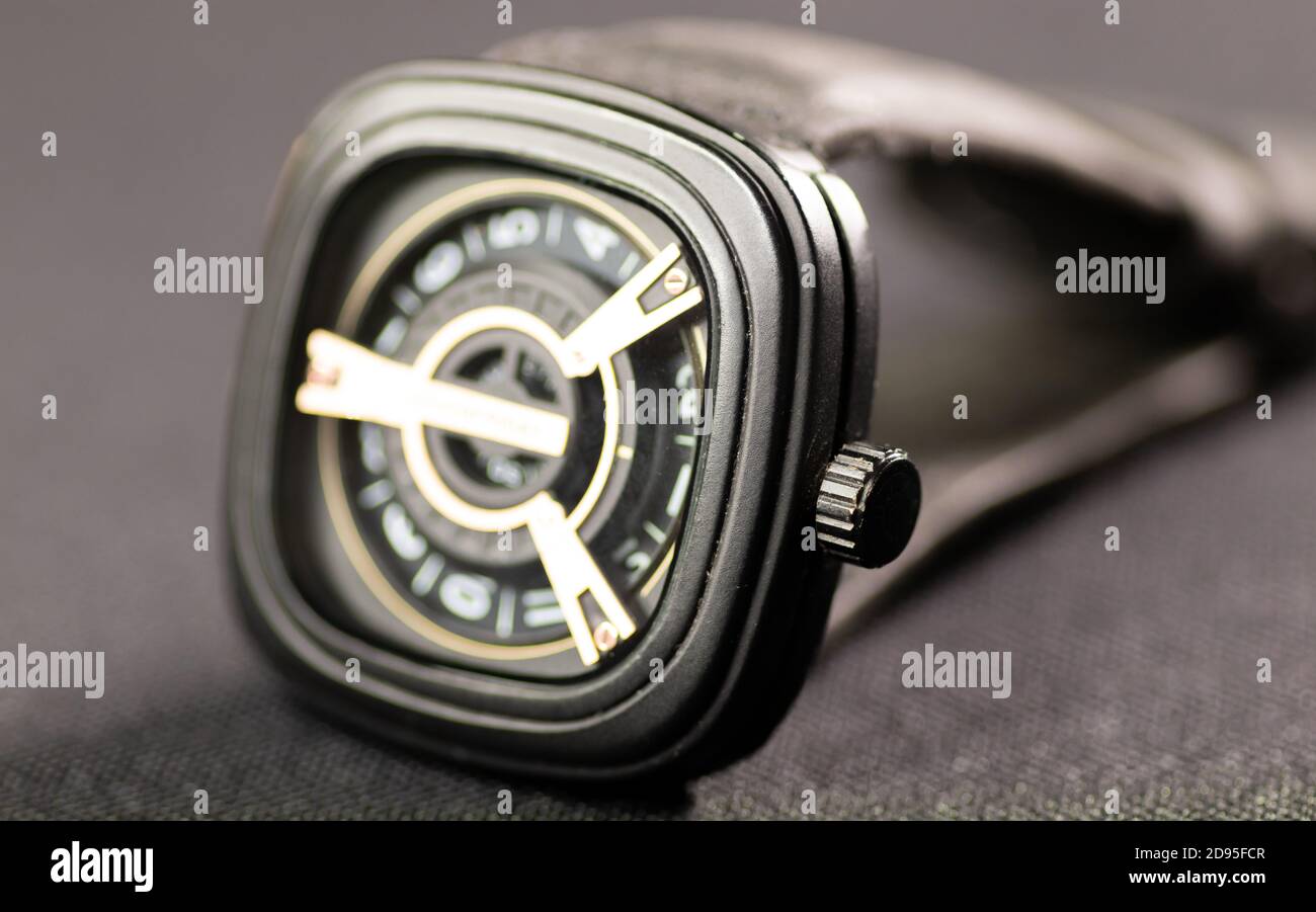 Square shaped used wrist watch on a slightly textured surface under ...