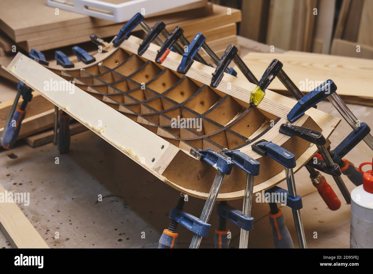 Joinery. Plywood bending process close-up. Gluing and clamping bend ...
