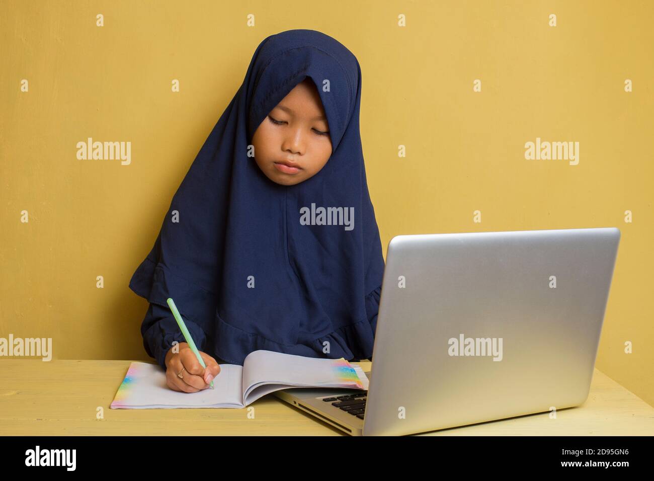 Smart Little asian muslim hijab girl using her laptop computer Stock ...