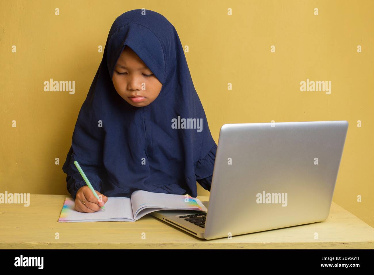 Smart Little asian muslim hijab girl using her laptop computer Stock ...