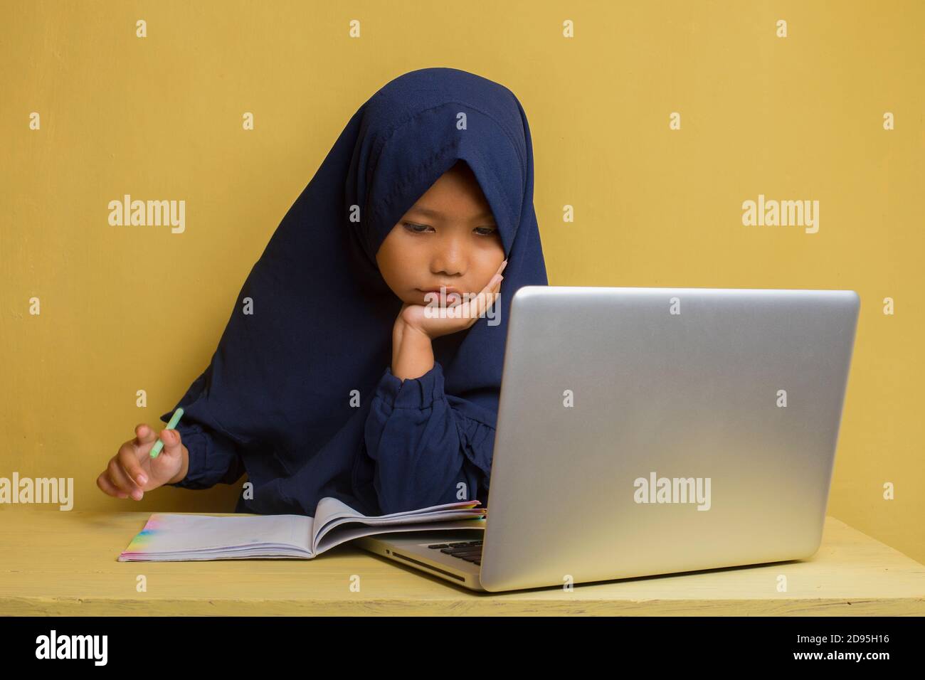 Smart Little asian muslim hijab girl using her laptop computer Stock ...