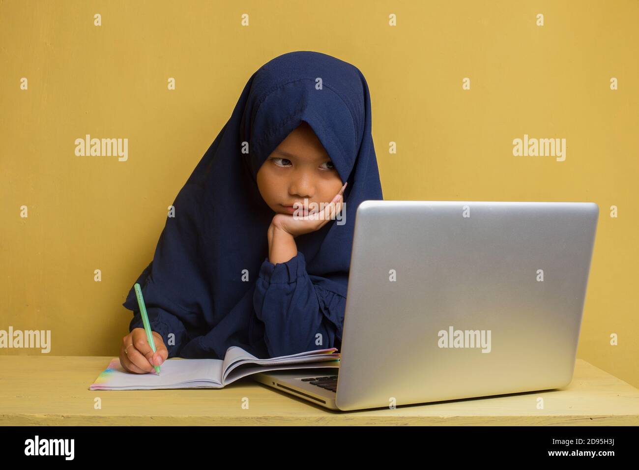 Smart Little asian muslim hijab girl using her laptop computer Stock ...