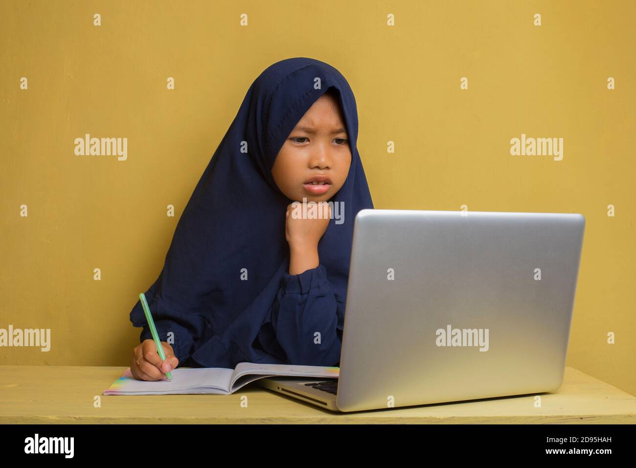 Smart Little asian muslim hijab girl using her laptop computer Stock ...