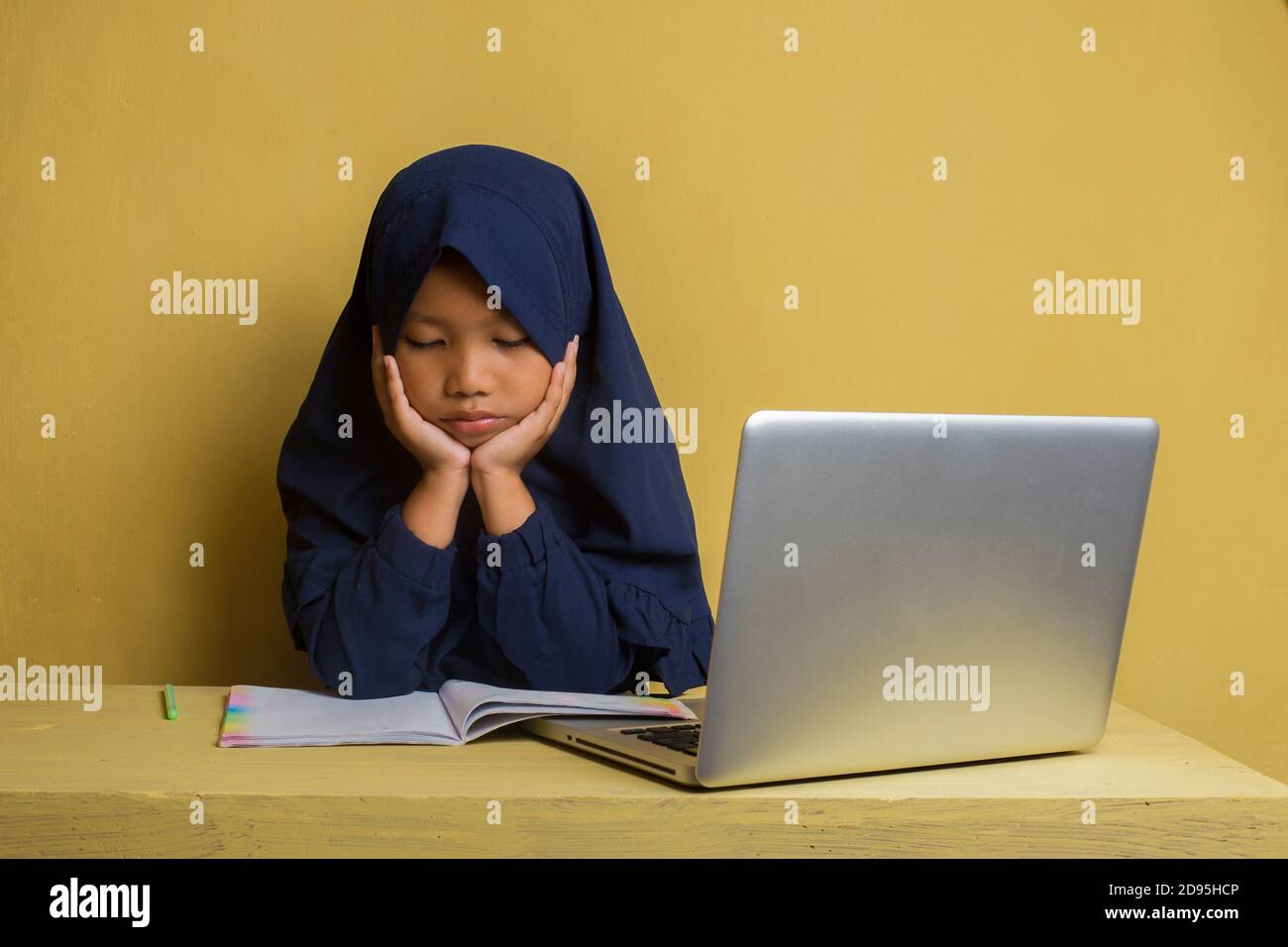 Smart Little asian muslim hijab girl using her laptop computer Stock ...