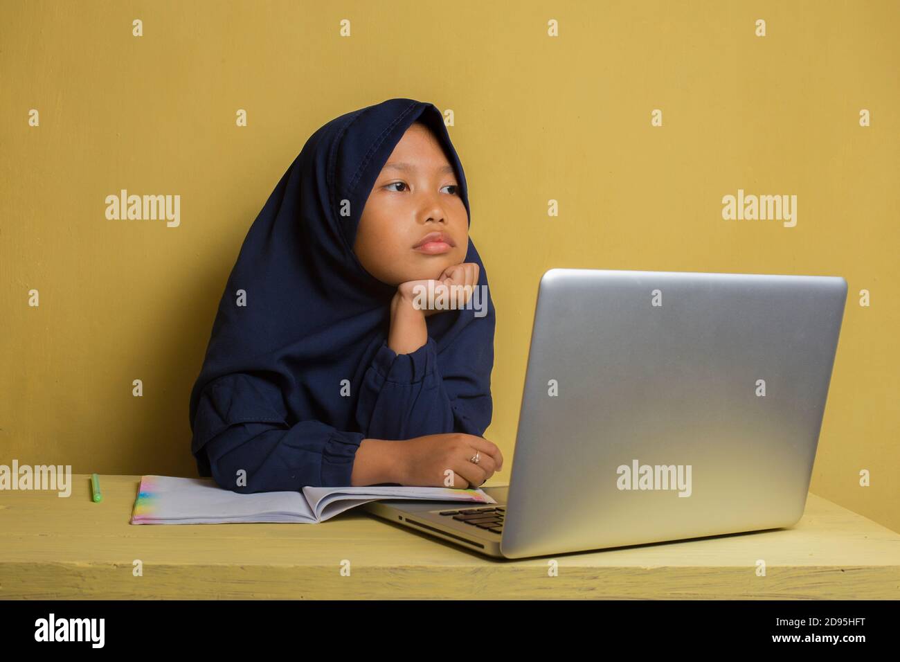 Smart Little asian muslim hijab girl using her laptop computer Stock ...