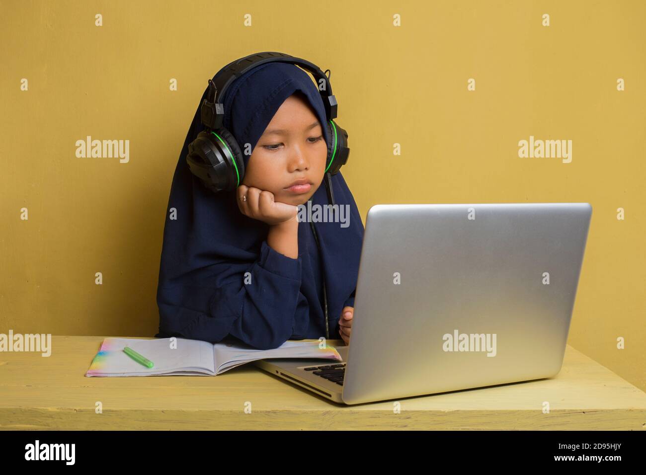 Smart Little asian muslim hijab girl using her laptop computer Stock ...