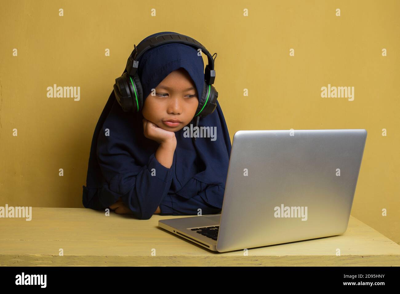 Smart Little asian muslim hijab girl using her laptop computer Stock ...