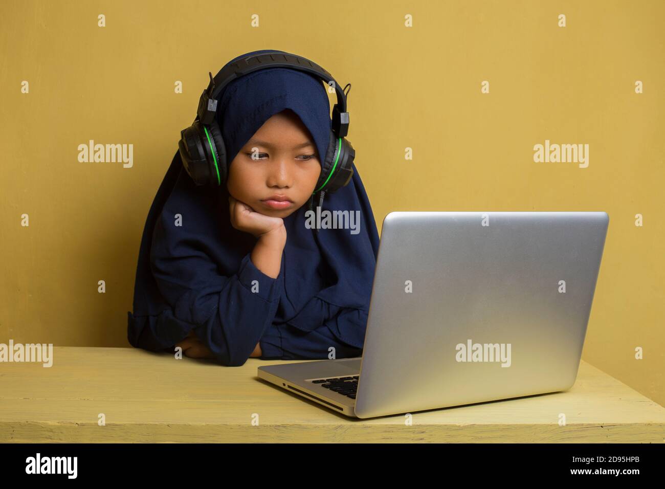 Smart Little asian muslim hijab girl using her laptop computer Stock ...