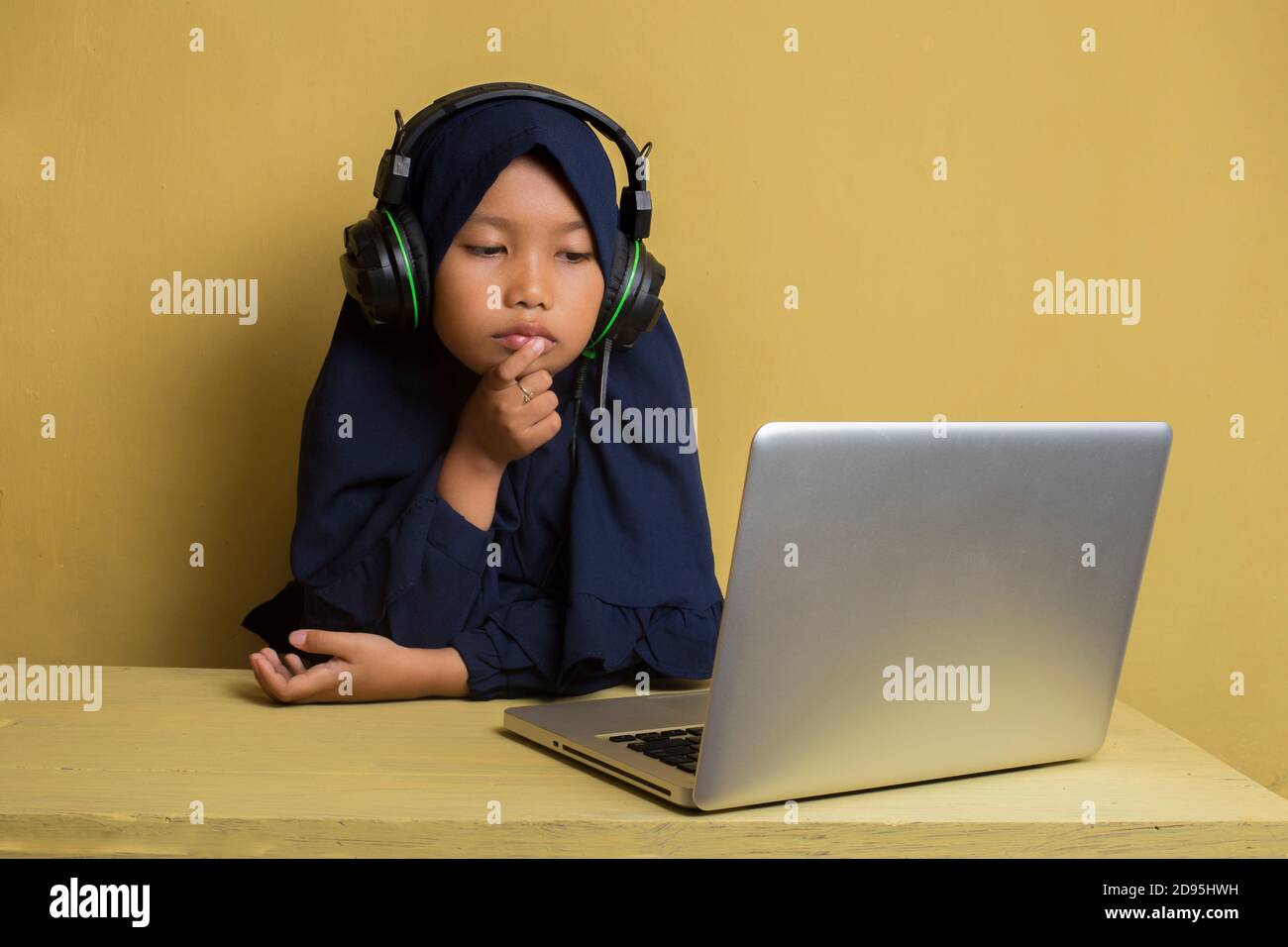 Smart Little asian muslim hijab girl using her laptop computer Stock ...