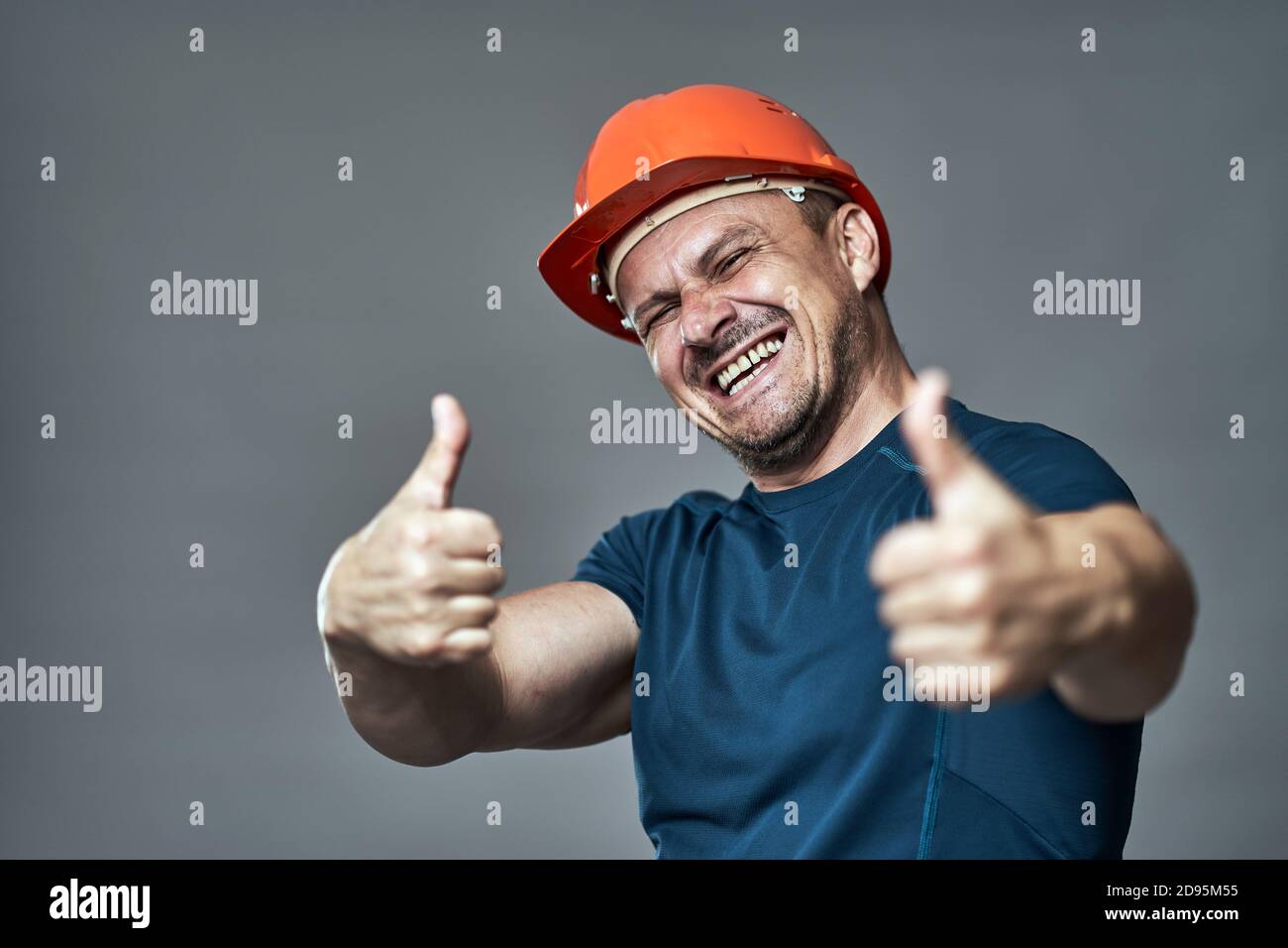 Engineer in hard hat making thumbs up sign Stock Photo - Alamy