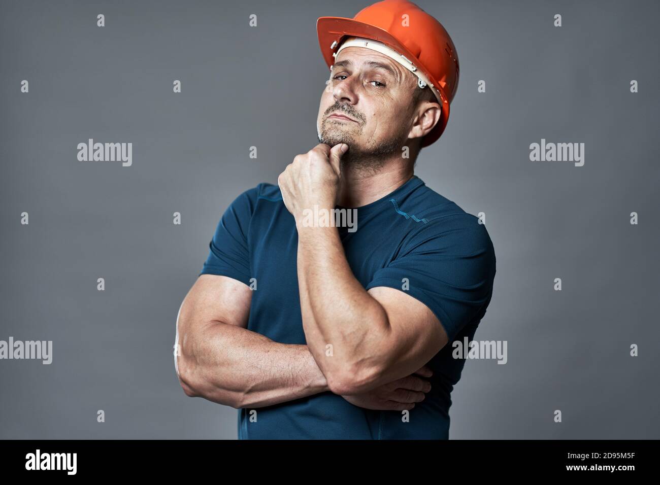 Suspicious engineer in hardhat with a doubtful expression Stock Photo ...