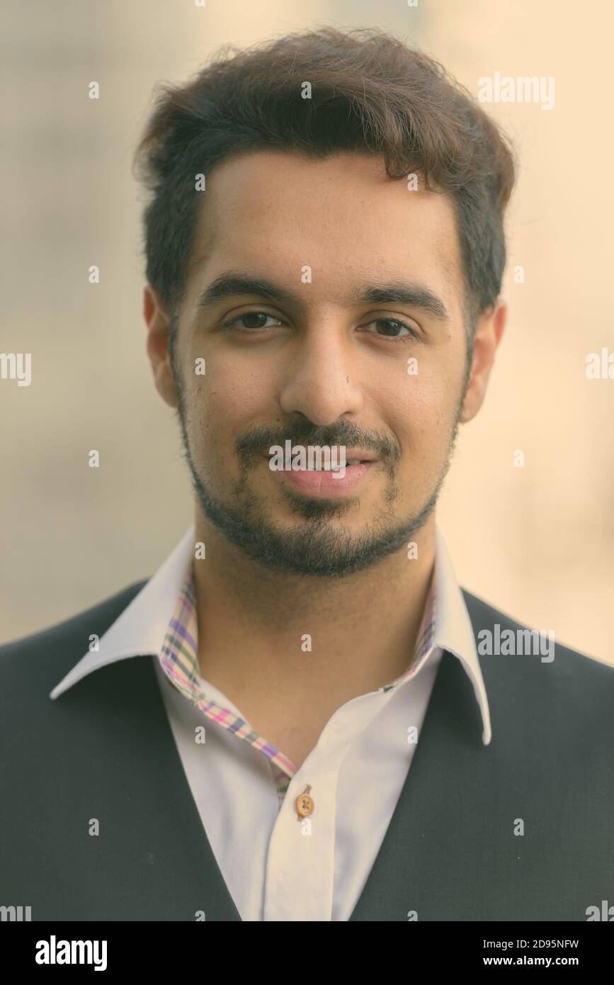 Face of young happy Indian man smiling outdoors in the city Stock Photo ...