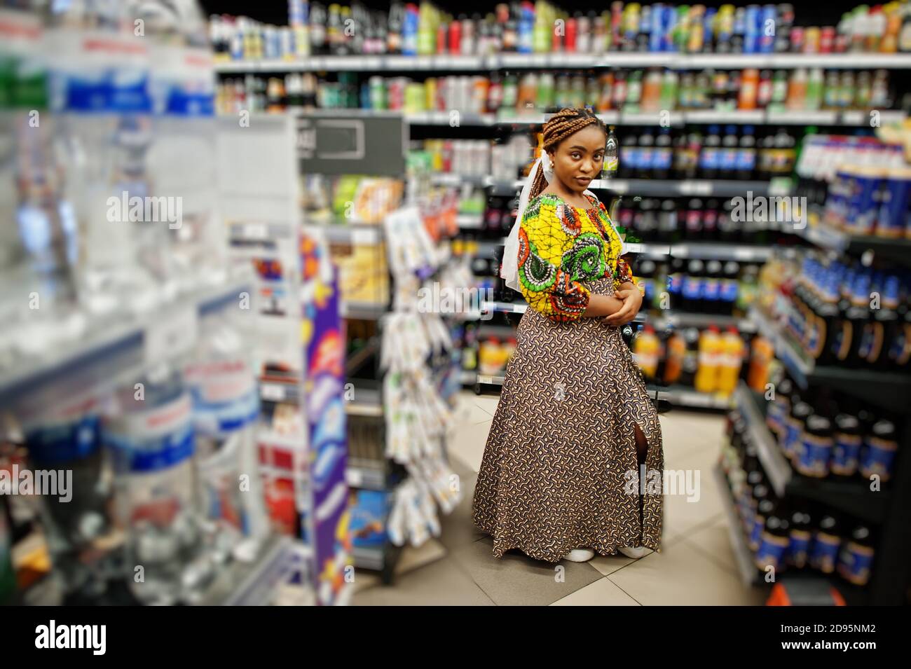 Happy african woman in traditional clothes and veil looking product at ...