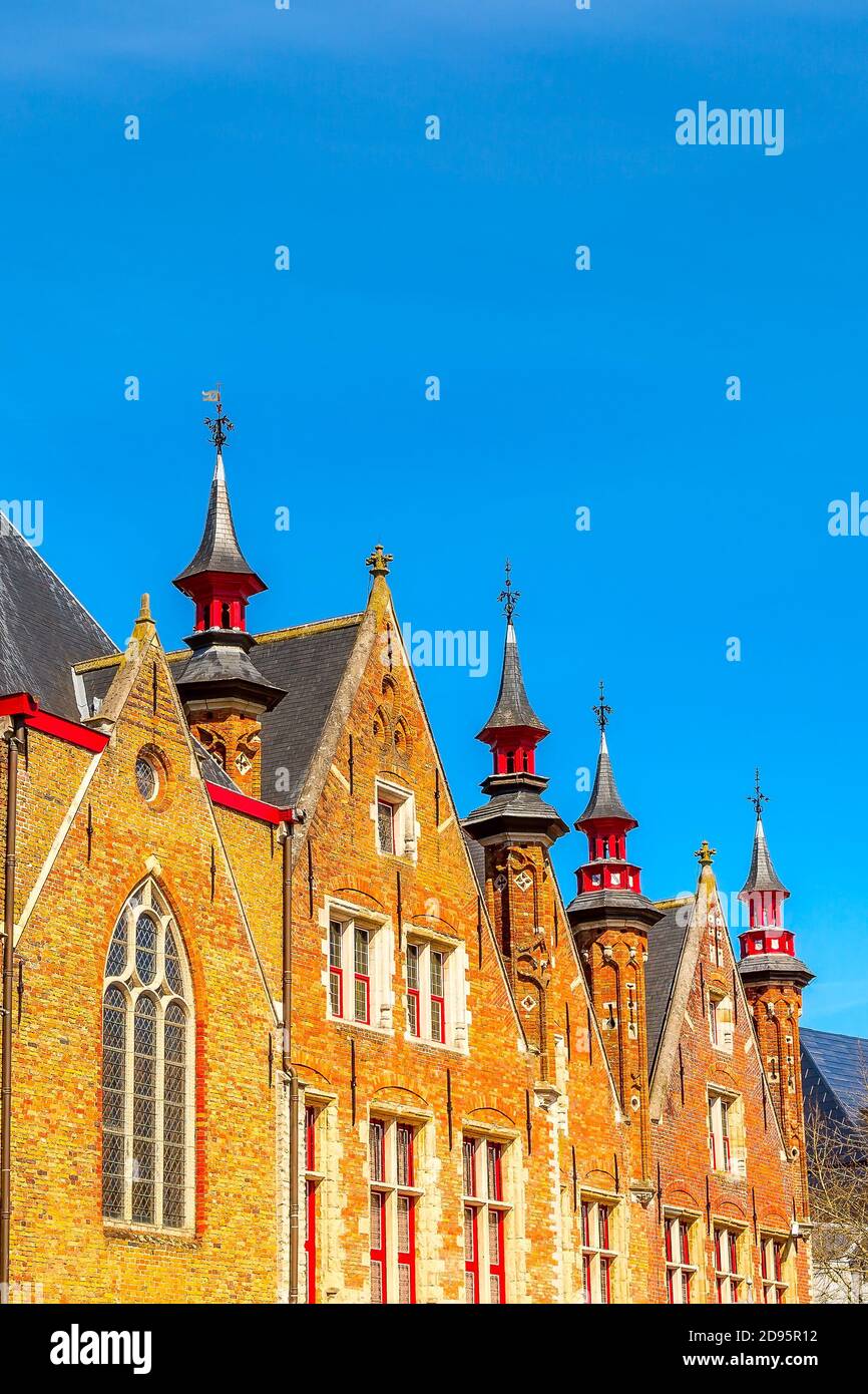 Traditional medieval brick house exterior against blue sky in Brugge ...