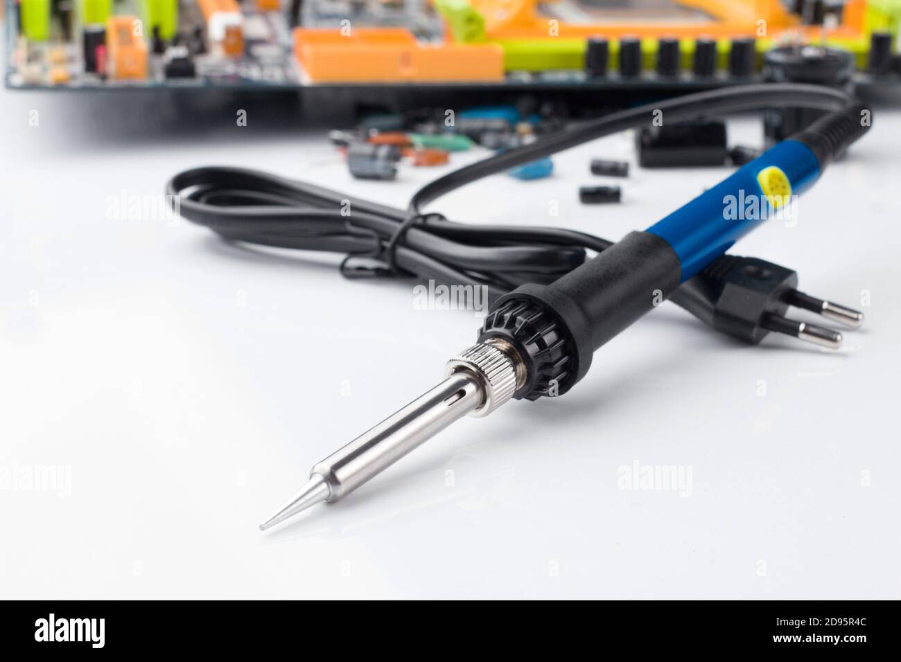 soldering iron on the background of a computer Board and capacitors in ...