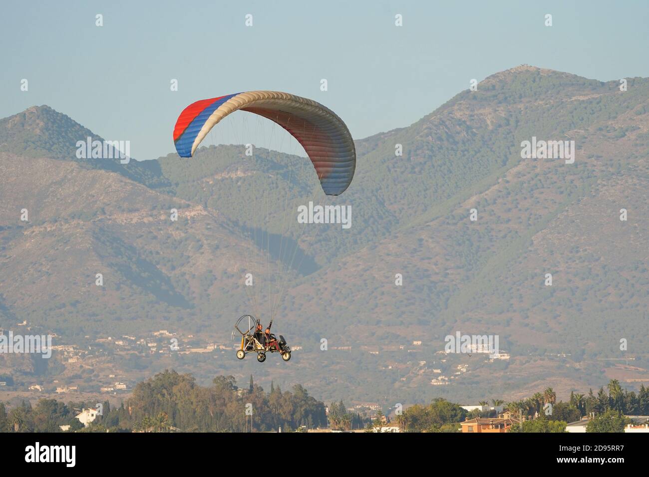 Motorized tandem paraglider, paragliding in front of mountain in ...