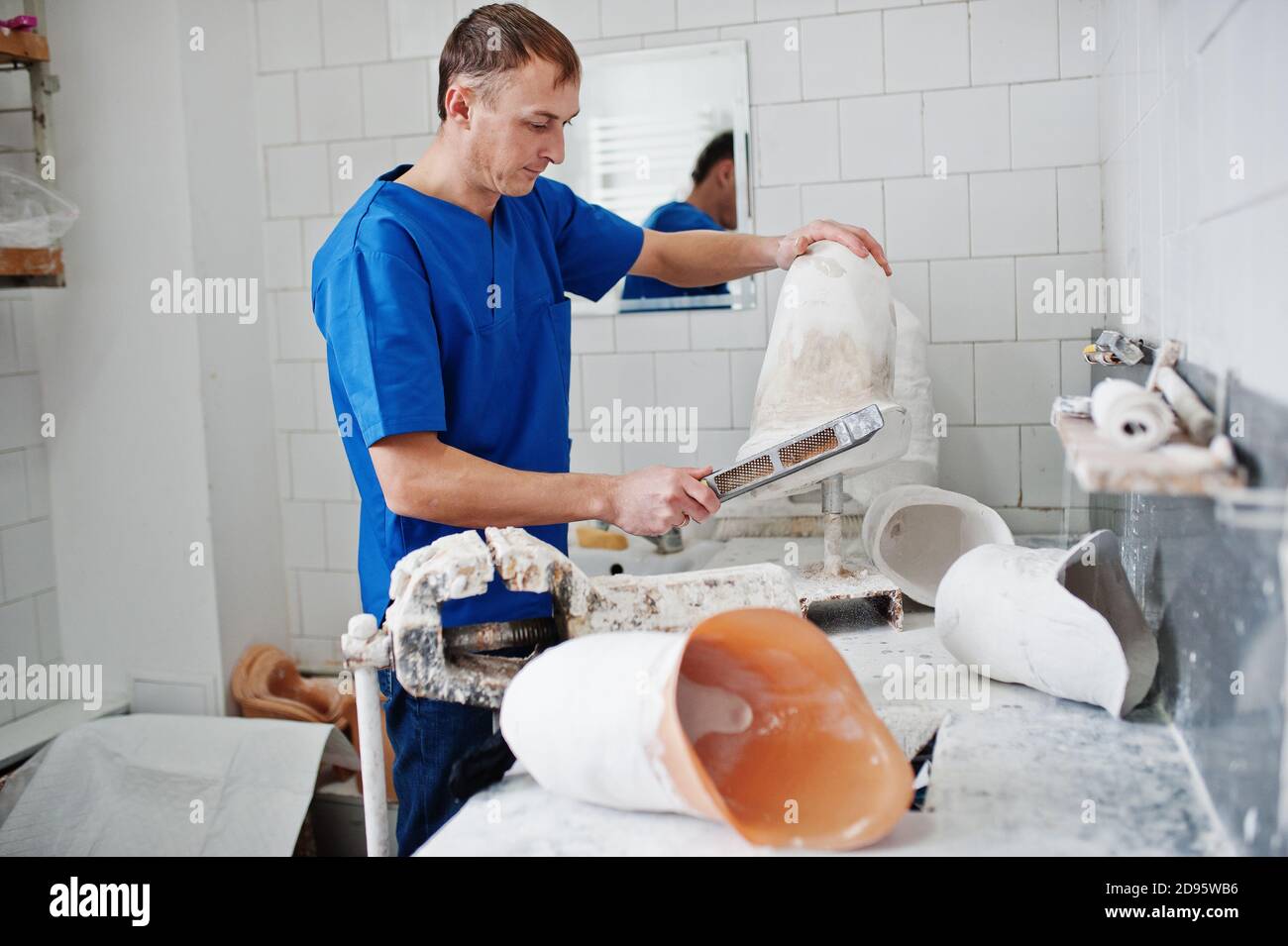 Prosthetist man making prosthetic leg while working in laboratory ...
