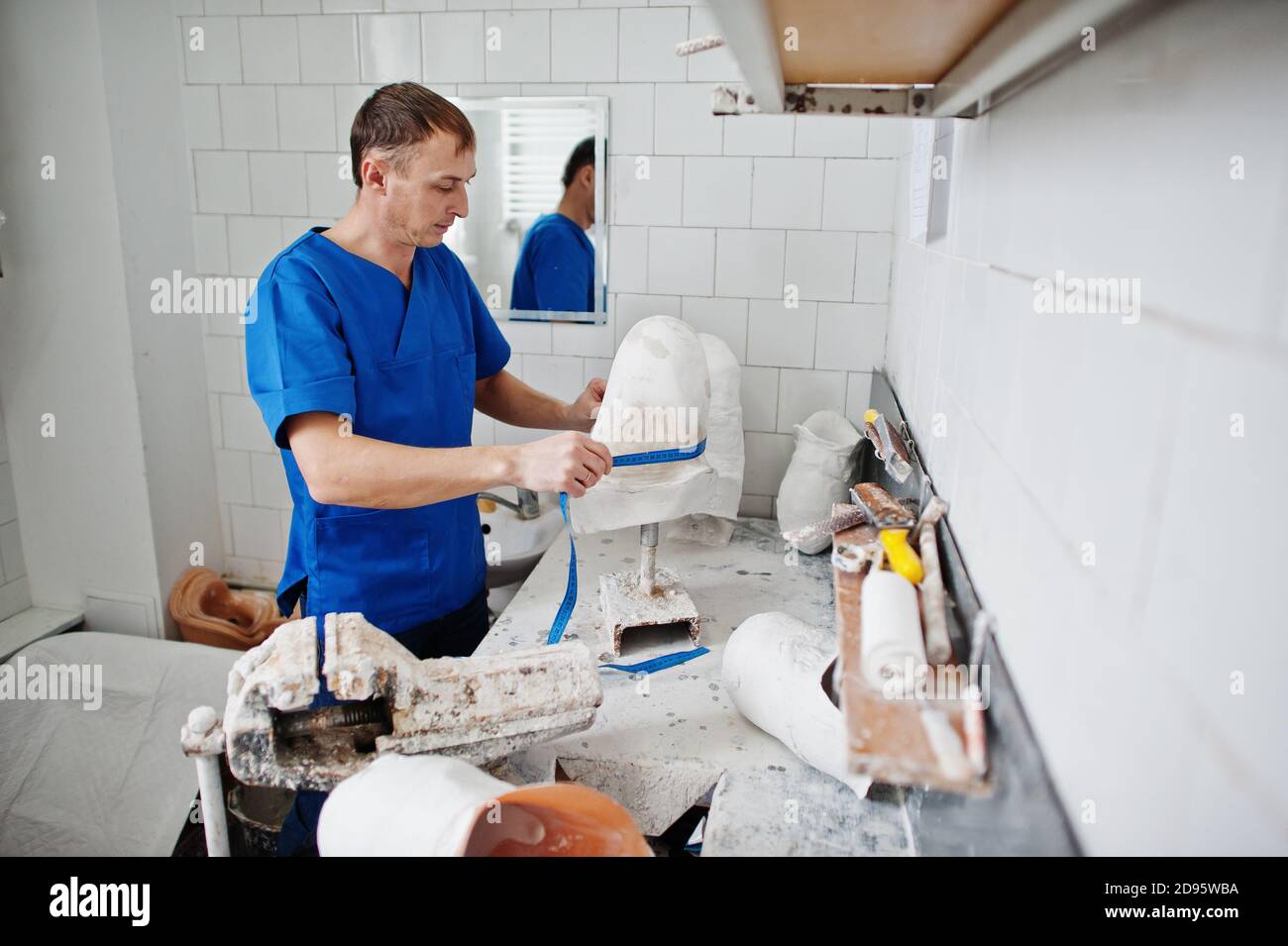Prosthetist man making prosthetic leg while working in laboratory ...