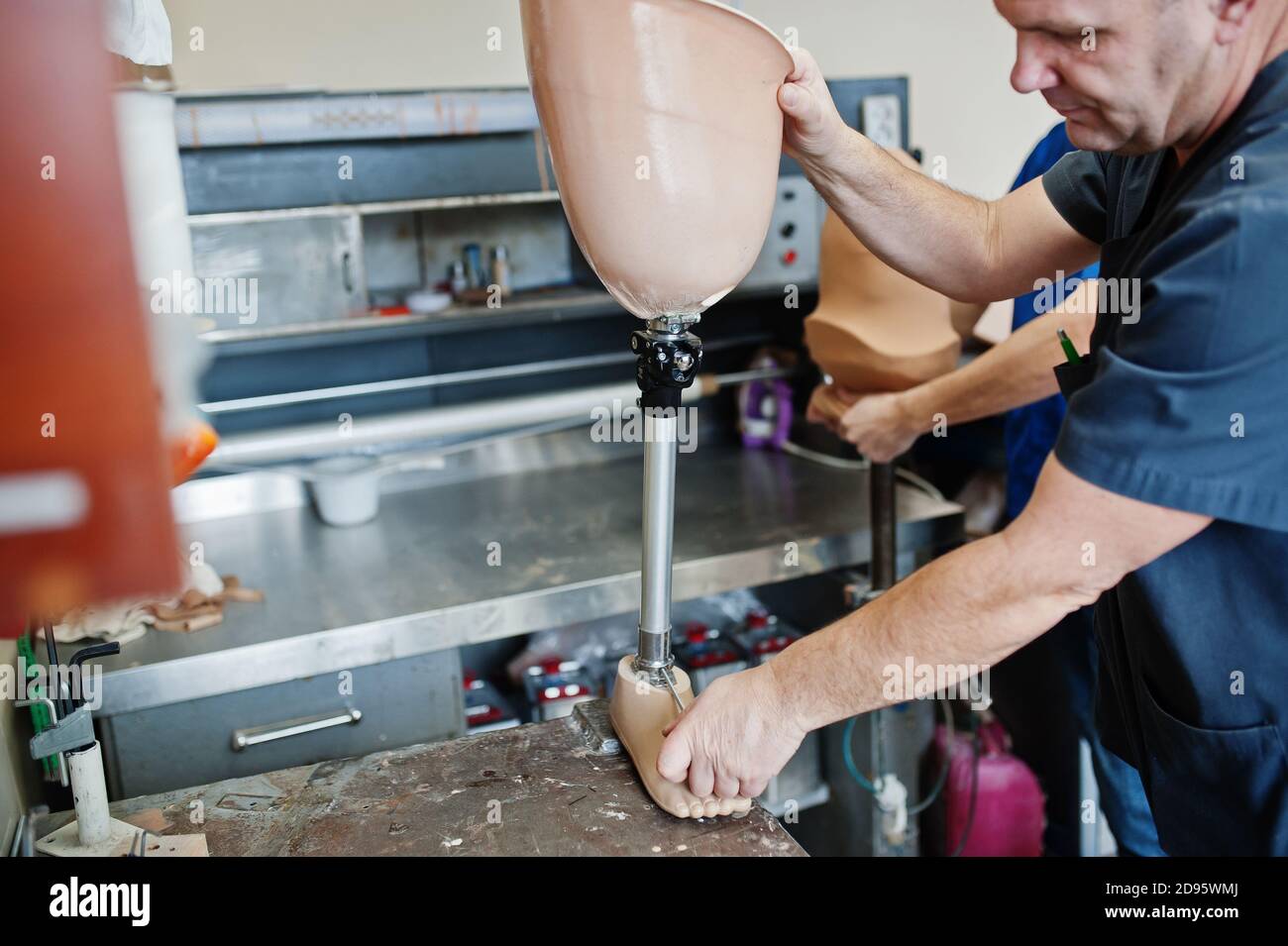 Two prosthetist man workers making prosthetic leg while working in ...