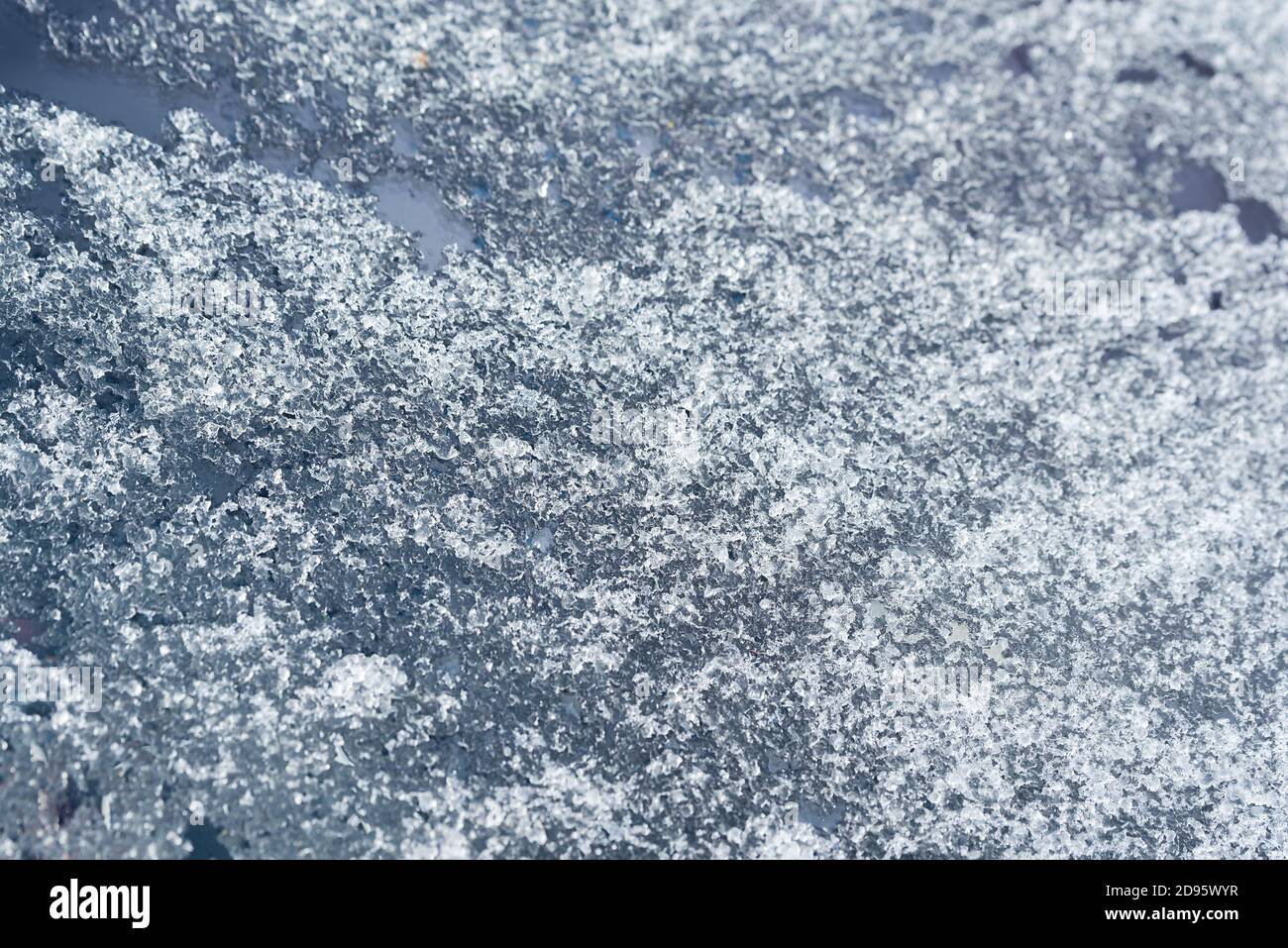 Melting snow on the car window. Close-up of ice crystals turning into ...
