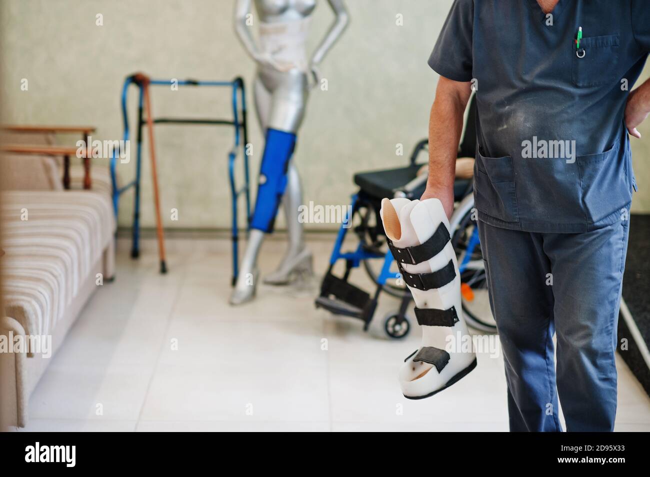 Prosthetist man with prosthetic leg in laboratory against wheelchair ...