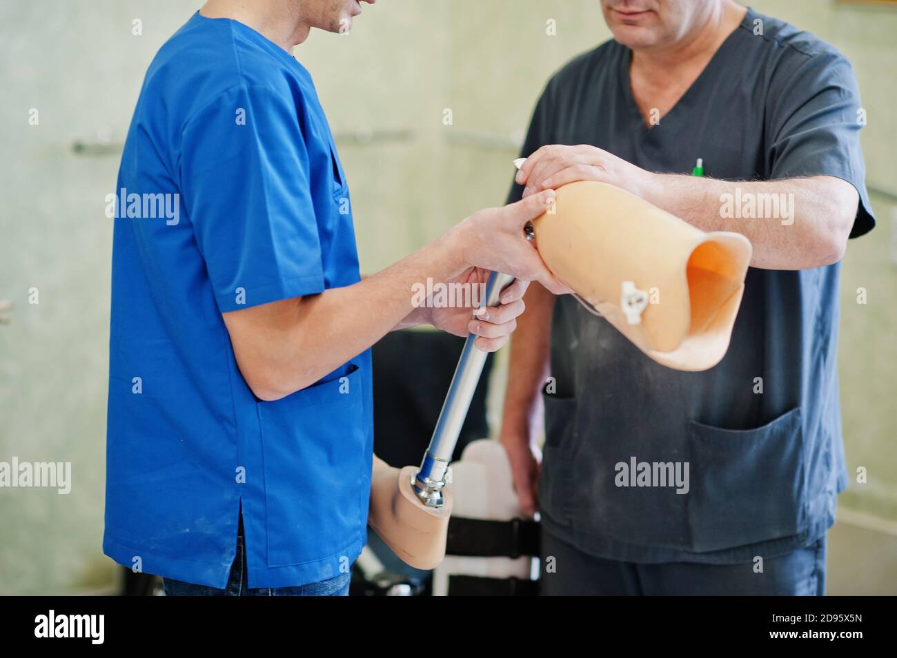 Two prosthetist man workers with prosthetic leg working in laboratory ...